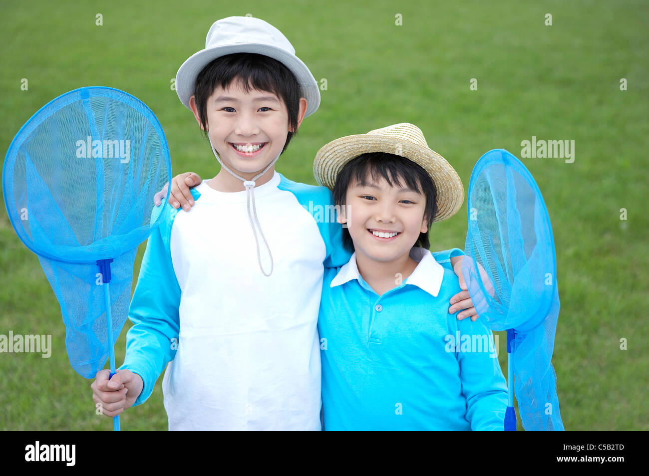 Portrait of boys holding fishing net Stock Photo - Alamy