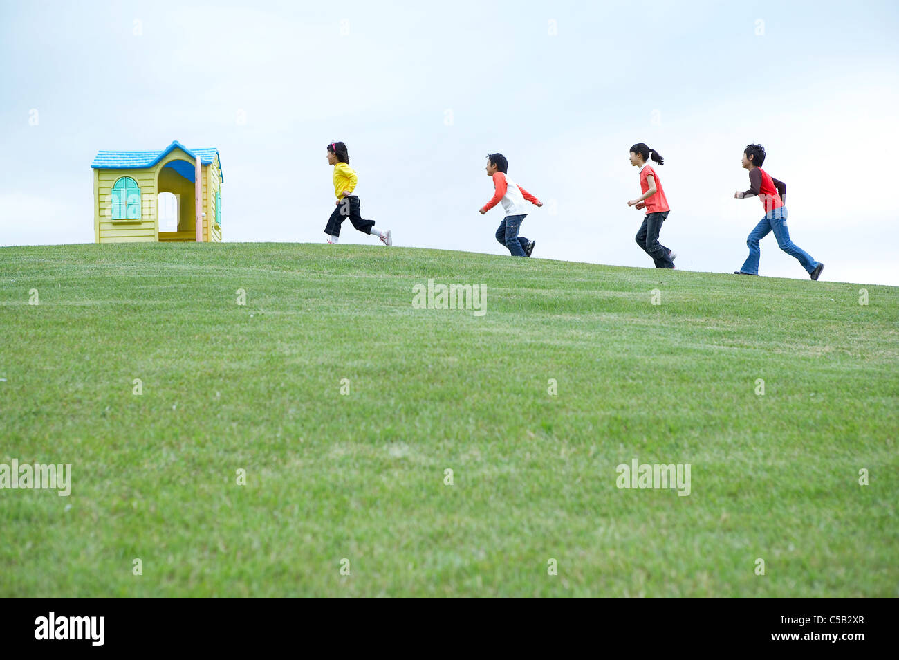Side view of children running on lawn towards toy house Stock Photo - Alamy