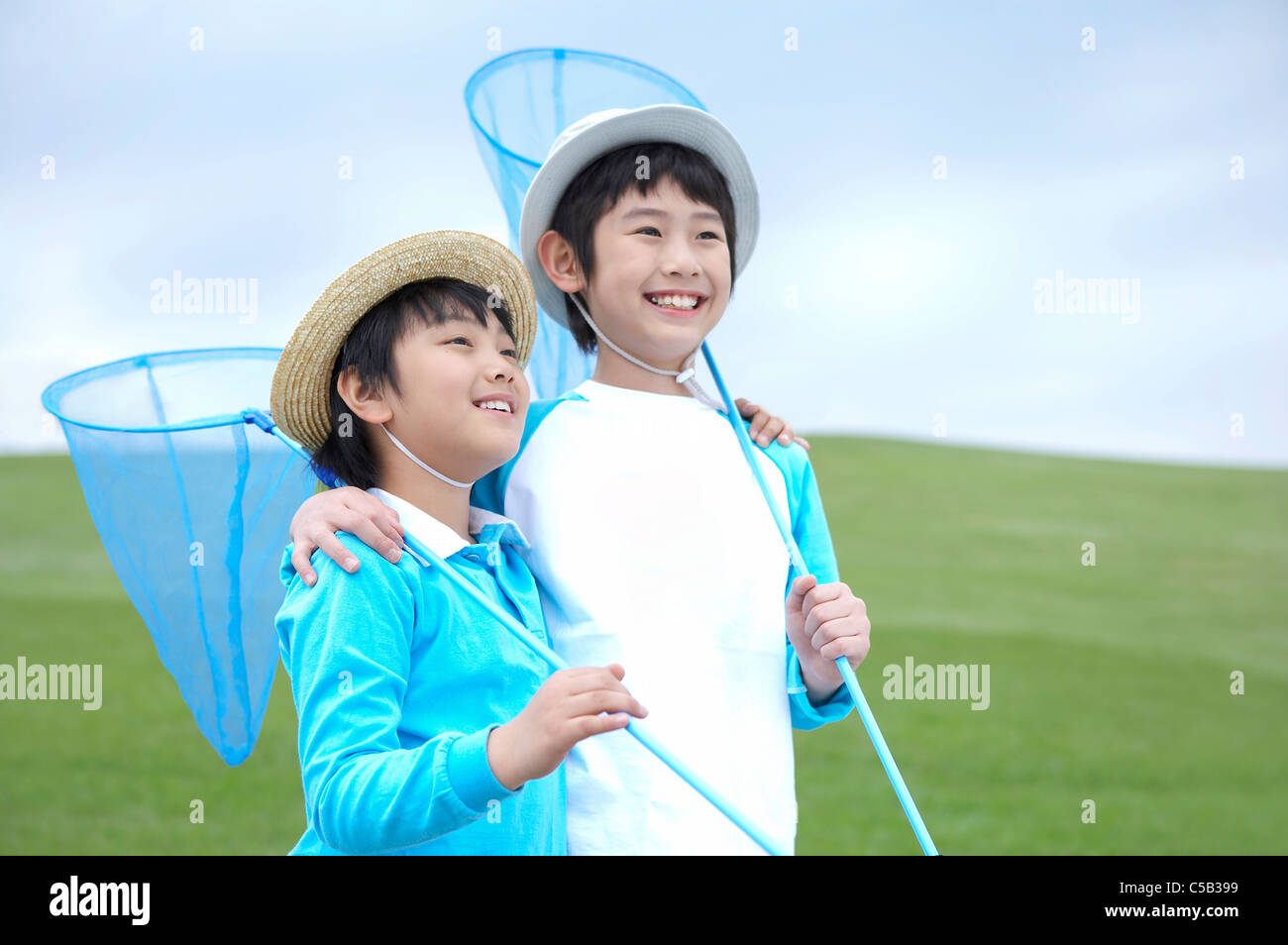 Side view of boys holding fishing net Stock Photo - Alamy
