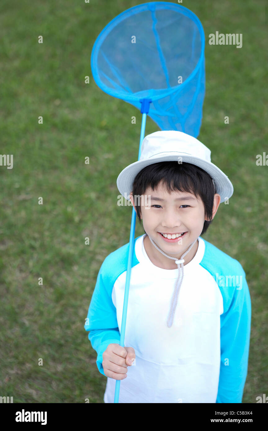 Portrait of boy holding fishing net in garden Stock Photo - Alamy