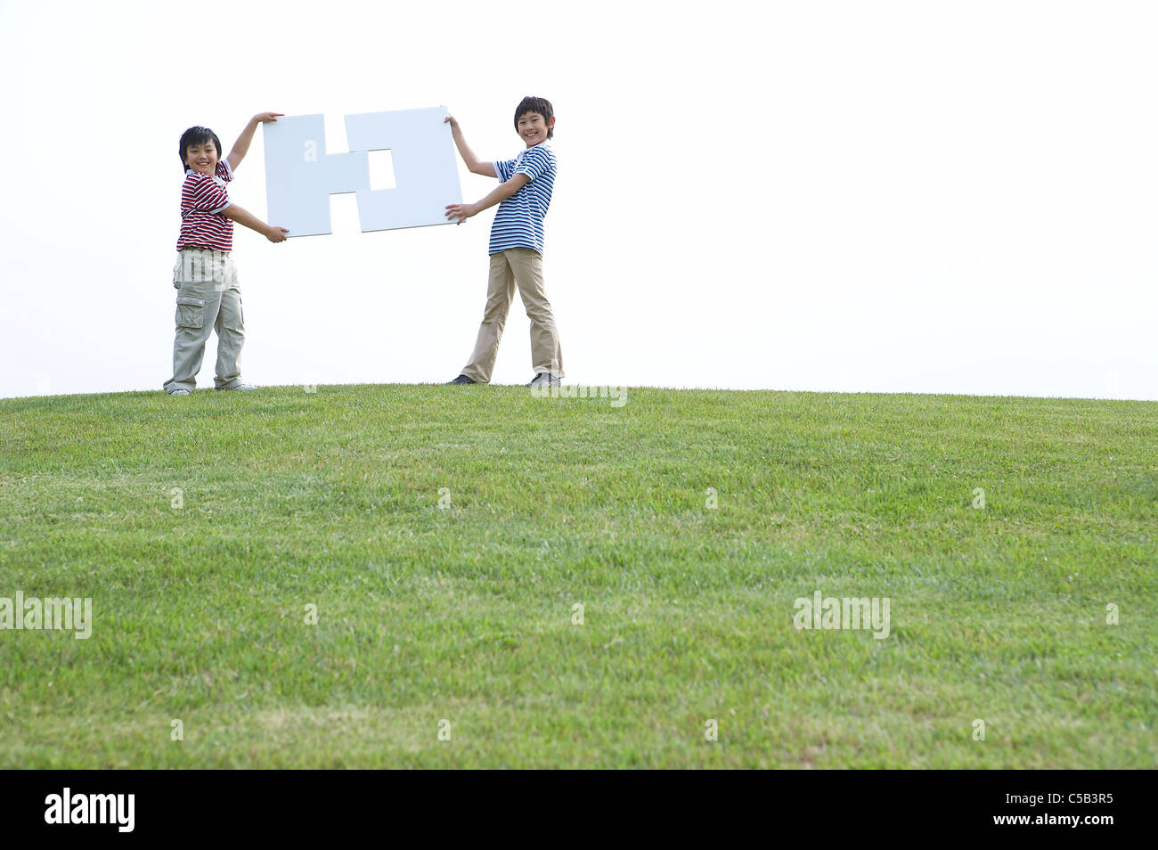 Side view of boys holding jigsaw puzzle Stock Photo - Alamy