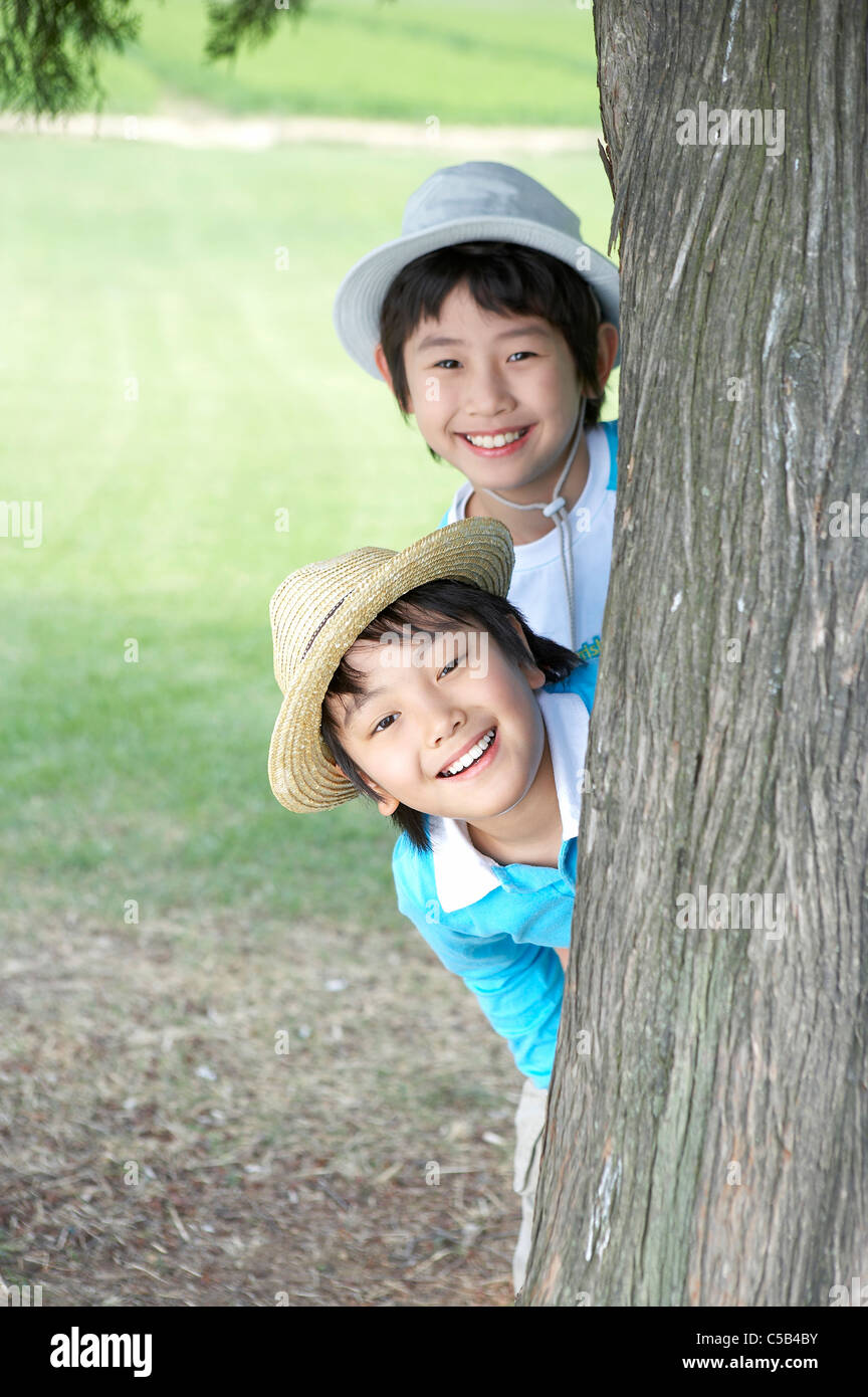 Boy hiding behind a tree hi-res stock photography and images - Alamy