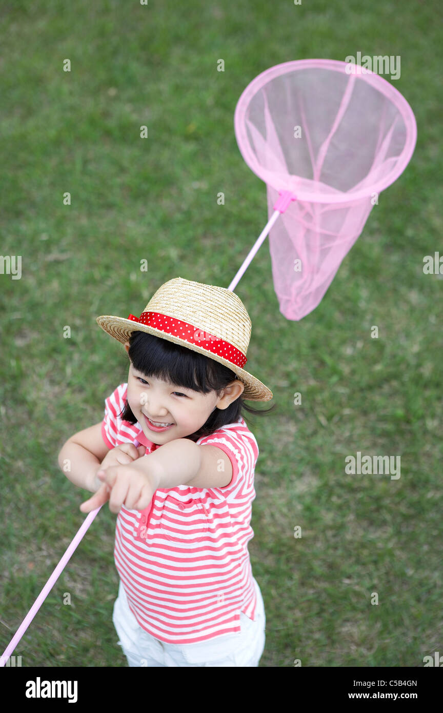 Elevated view of girl holding fishing net in garden Stock Photo - Alamy