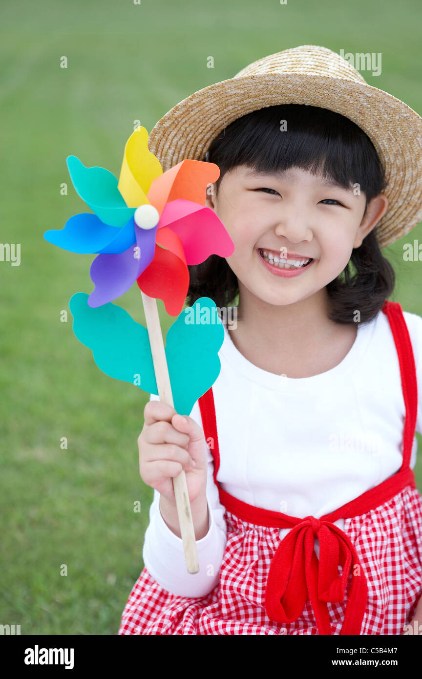 Portrait of girl holding pinwheel in lawn Stock Photo - Alamy