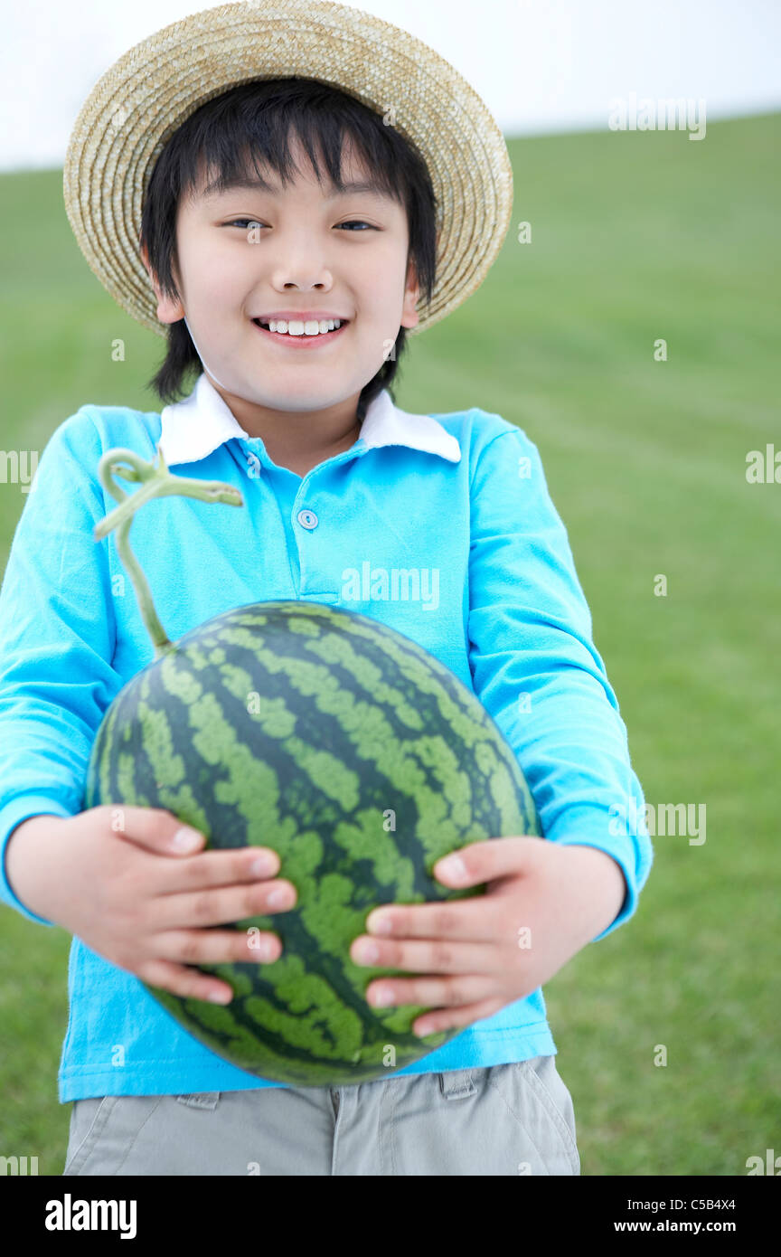 Portrait of boy carrying watermelon Stock Photo - Alamy