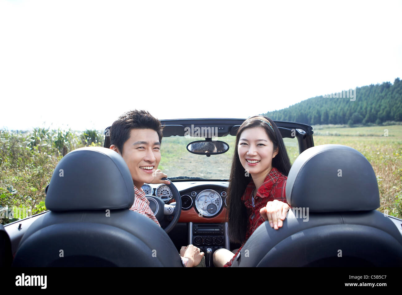 Portrait of young couple riding in convertible car Stock Photo - Alamy