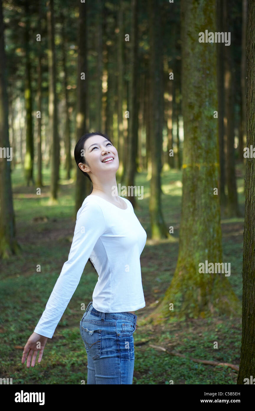 Young woman with arms outstretched in forest Stock Photo - Alamy