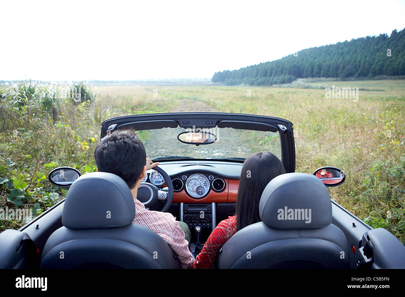 Rear view of young couple riding in convertible car Stock Photo - Alamy