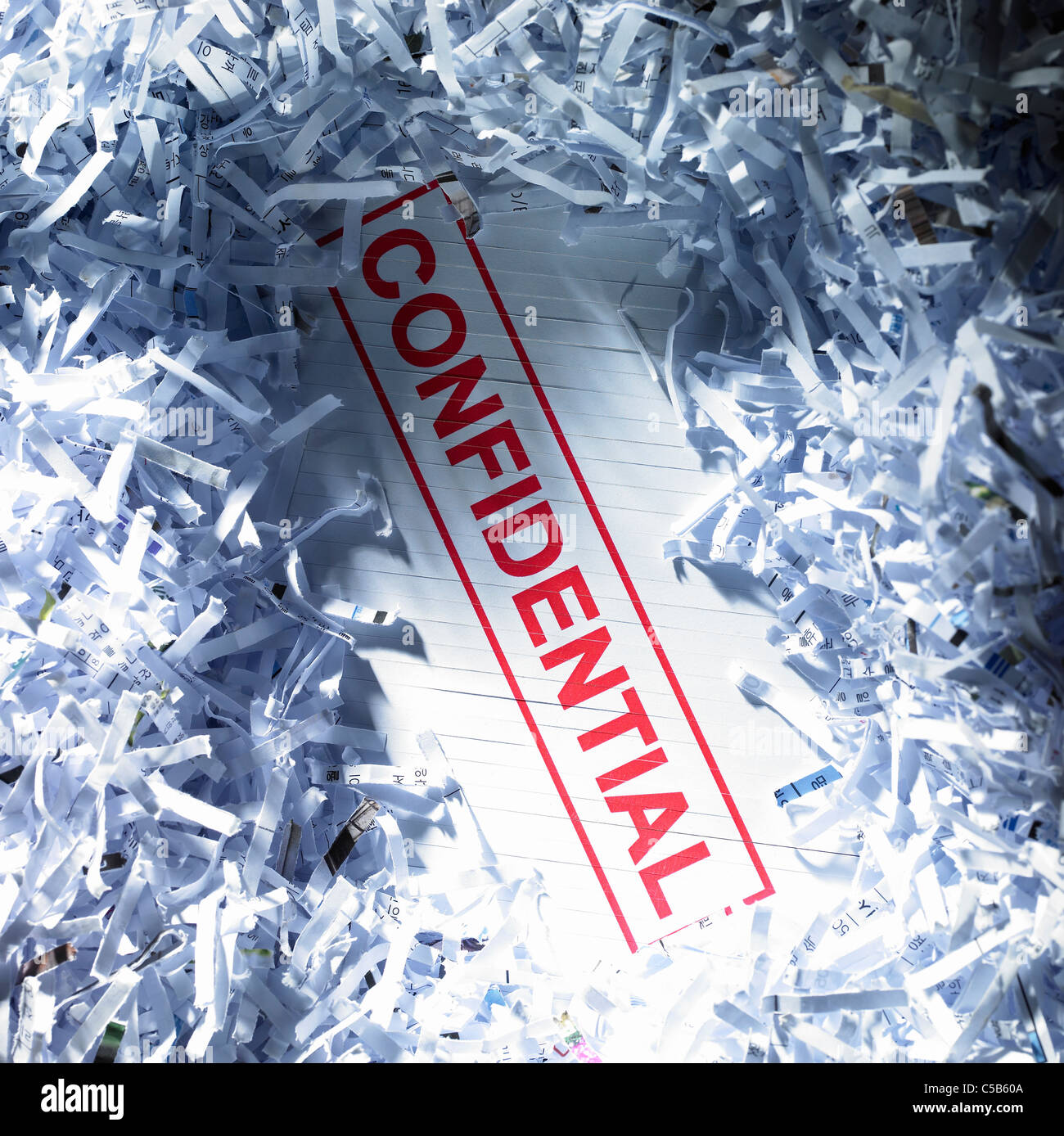 Confidential on paper by shredded paper Stock Photo - Alamy