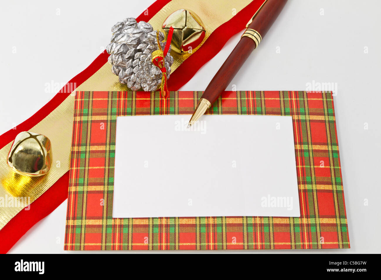 Plaid framed note with open space placed with pen and holiday items of ...