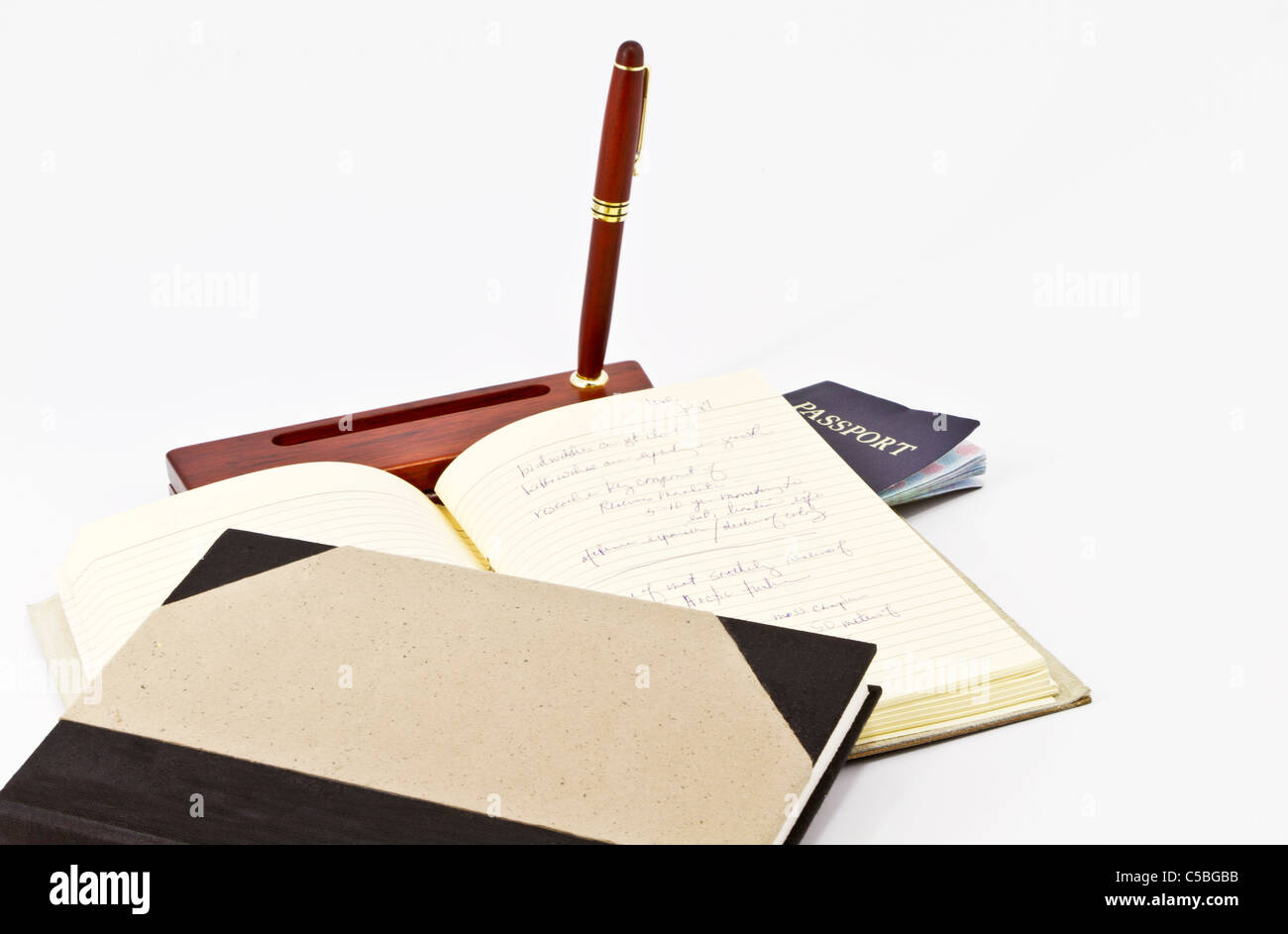 Open, notated journal, desk pen, passport, and 2nd journal Stock Photo ...