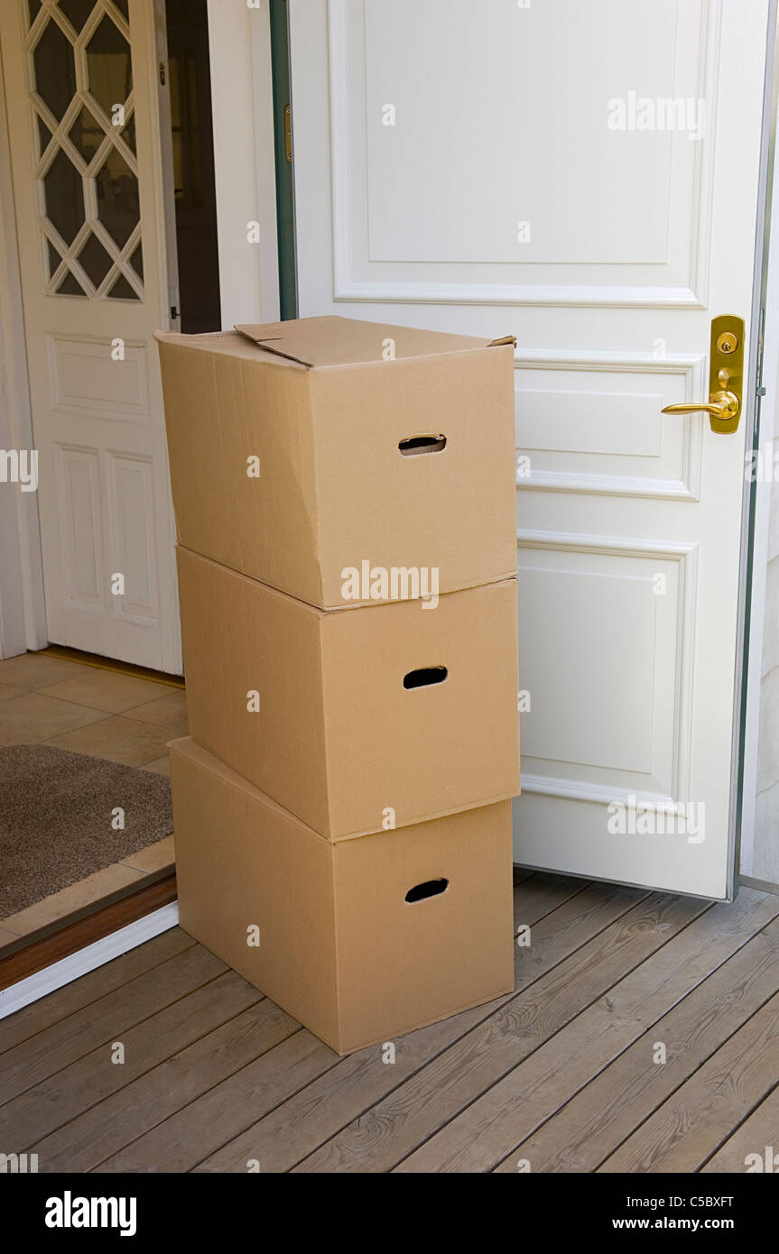 Stack of moving boxes at the door Stock Photo - Alamy