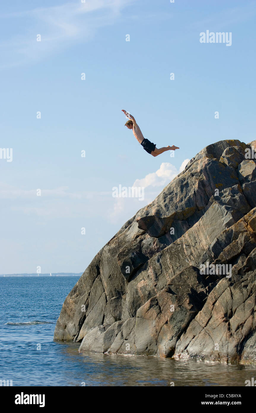 Young man jumping from a cliff hi-res stock photography and images - Alamy