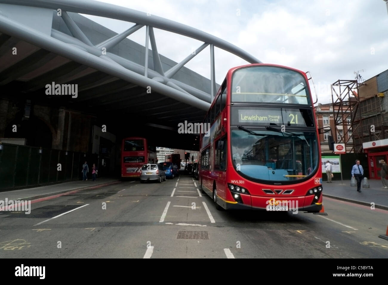 A red double-decker 21 bus destined for Lewisham passing under Network ...