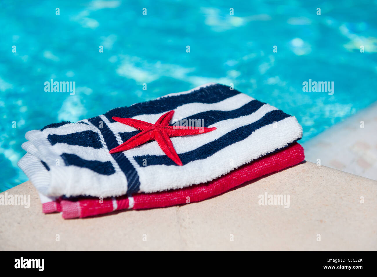 Folded towels and startfish near the swimming pool Stock Photo - Alamy