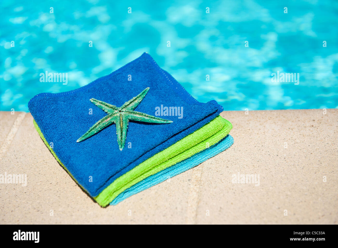 Folded towels and startfish near the swimming pool Stock Photo - Alamy
