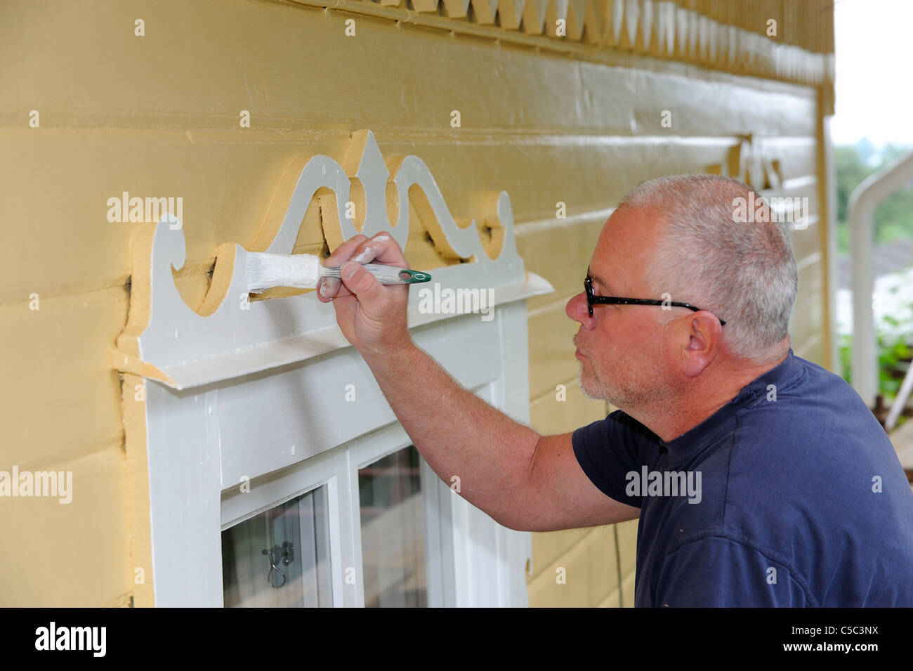 Side view of a senior man painting the house window Stock Photo - Alamy