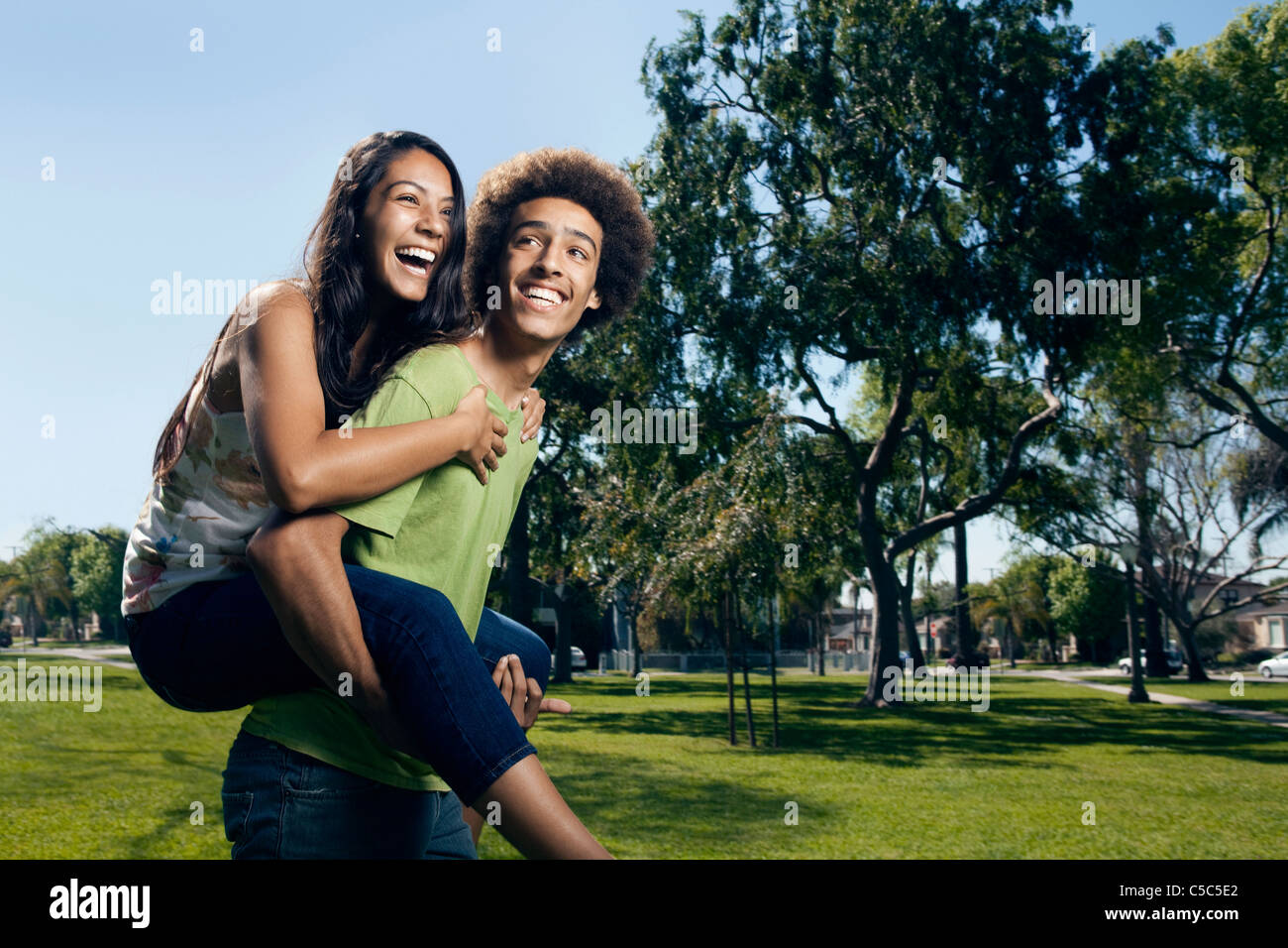 Teenager carrying girlfriend on his back in park Stock Photo - Alamy