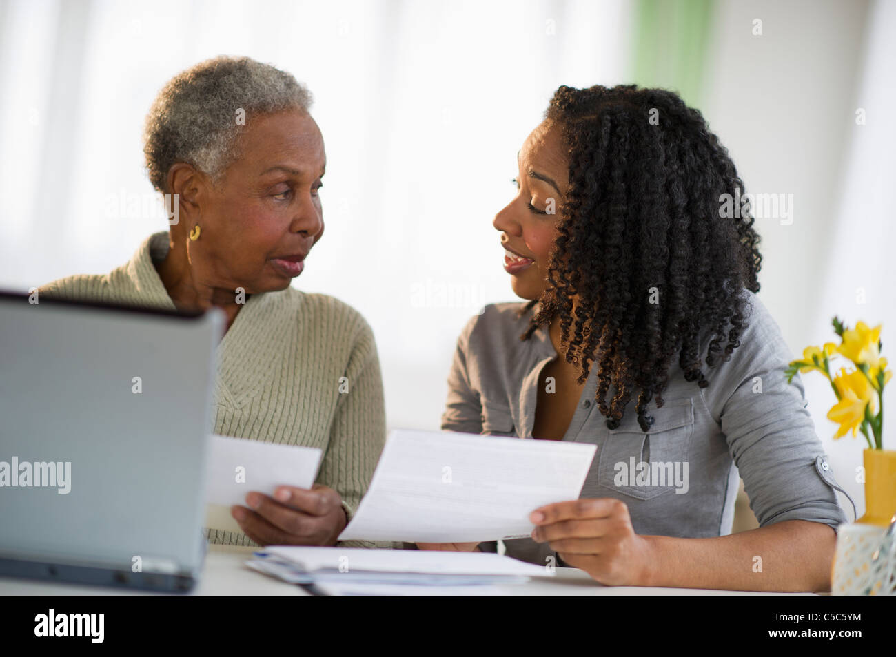 Daughter helping mother pay bills online Stock Photo - Alamy