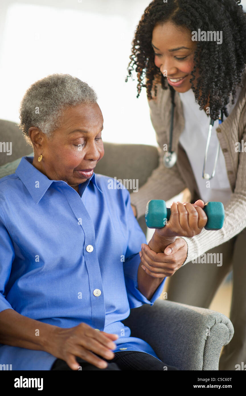 Nurse helping woman exercise with dumbbells Stock Photo - Alamy