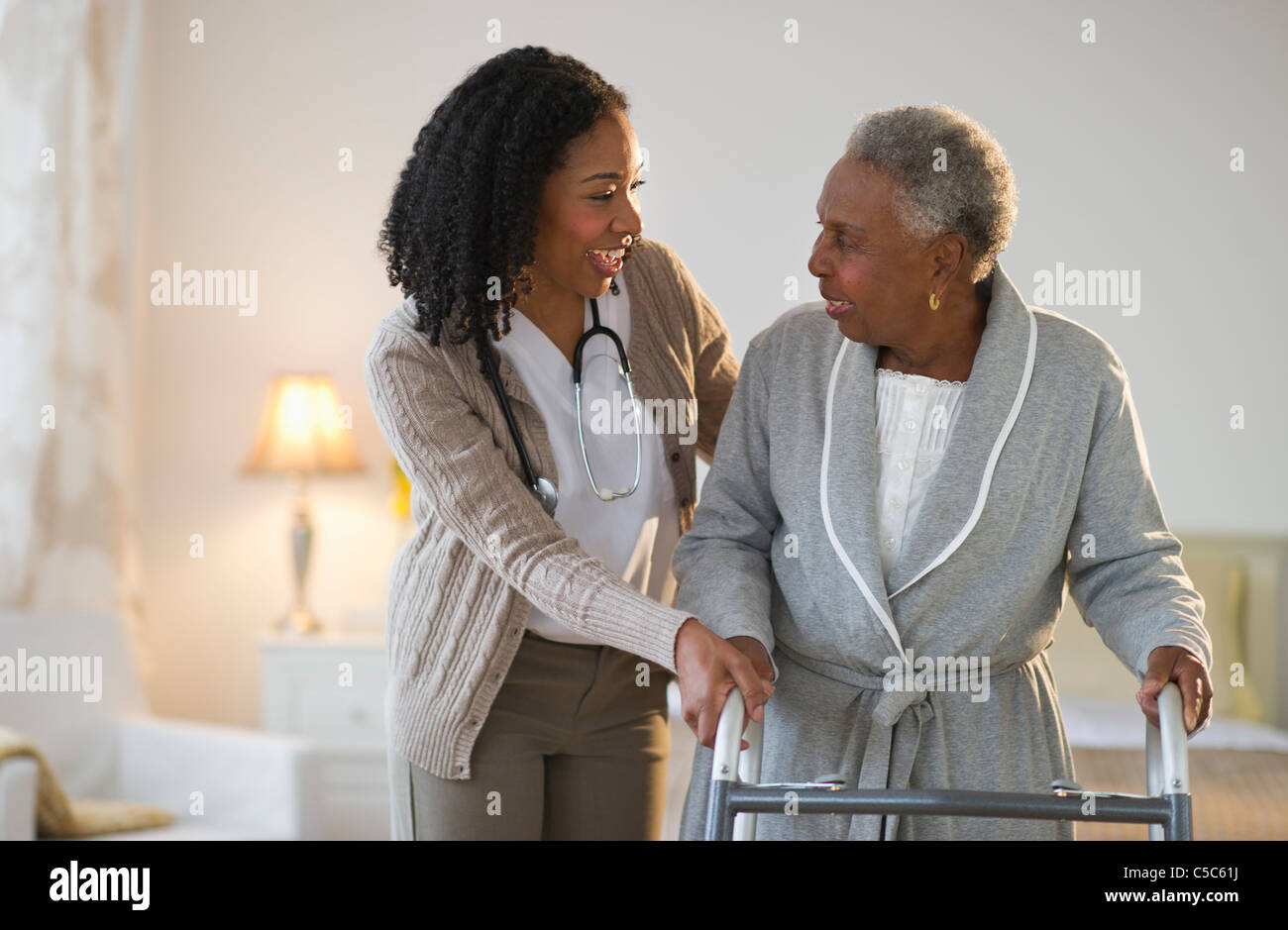 Nurse helping woman walk with walker Stock Photo - Alamy