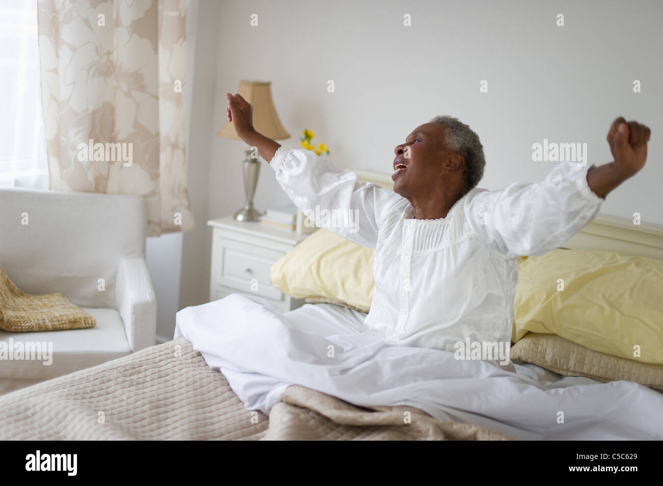 Black woman waking up in bed Stock Photo - Alamy