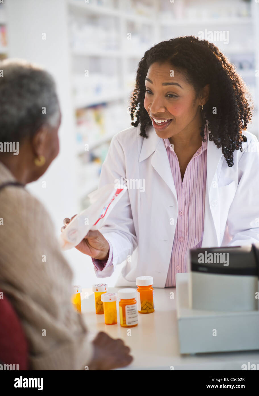 Pharmacist handing medication to woman Stock Photo - Alamy