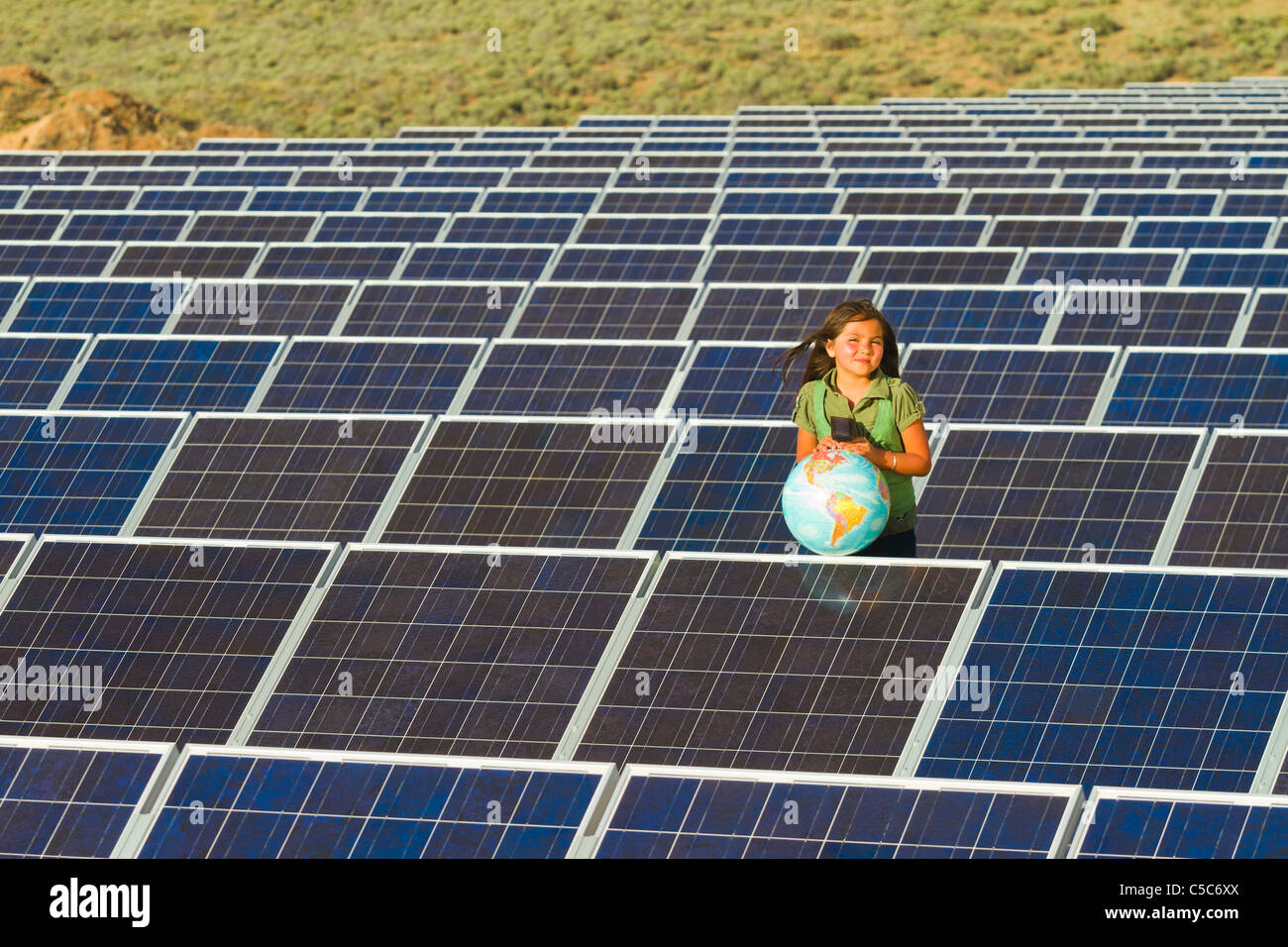 Native American girl standing near solar panels holding globe Stock ...