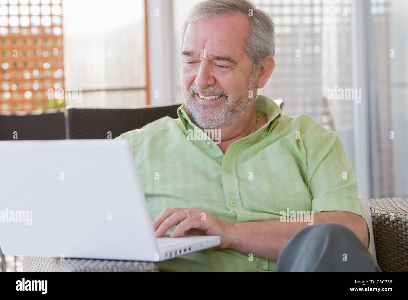 Smiling senior man typing hi-res stock photography and images - Alamy