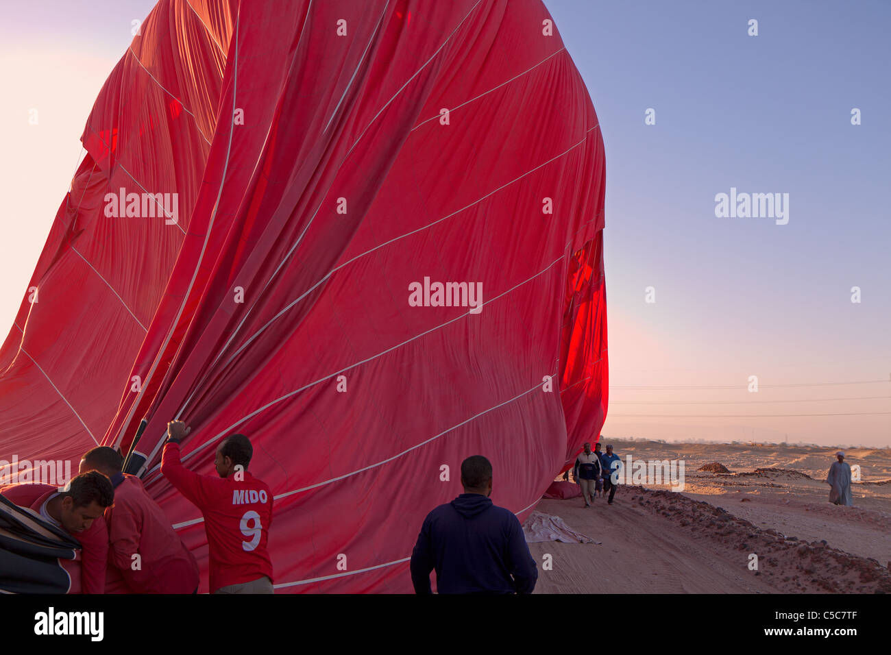 Ground crew rush to collapse the canopy at the end of a hot air balloon ...