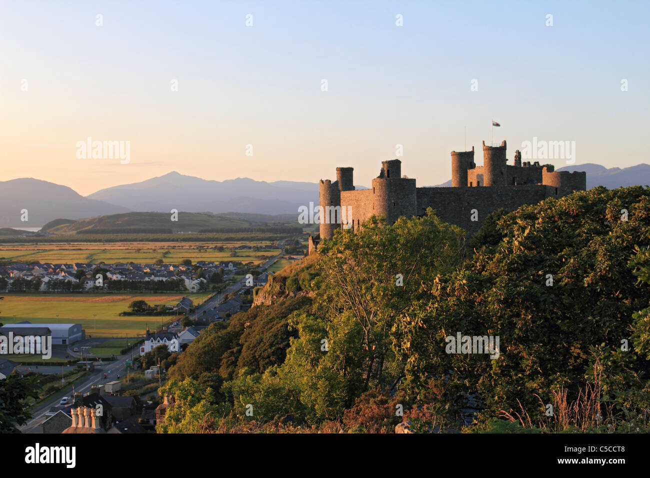 Dusk at Harlech castle with the triangular peak of Mount Snowdon in the ...