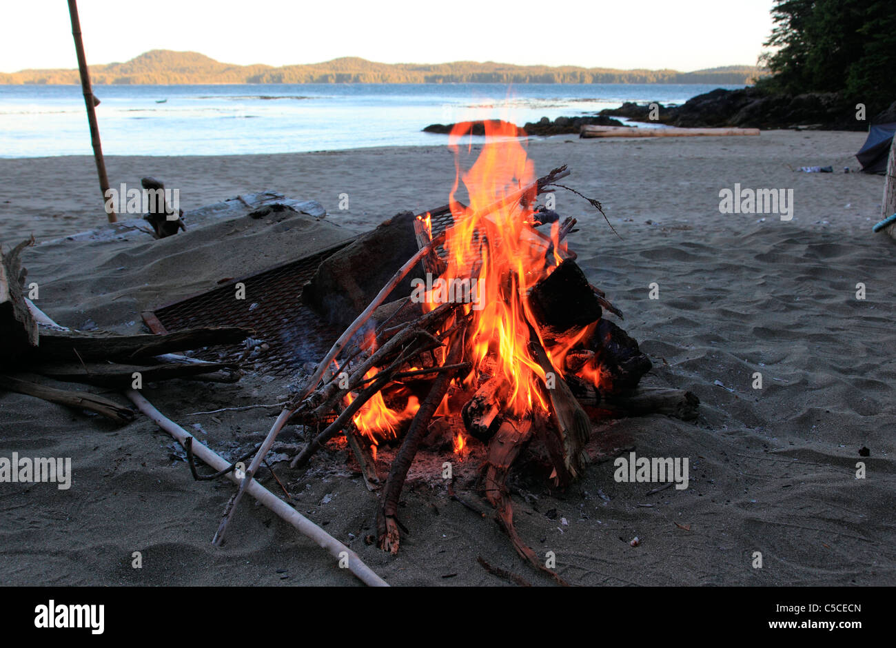 Camp fire on a sandy beach near Tofino BC Canada in the early evening ...