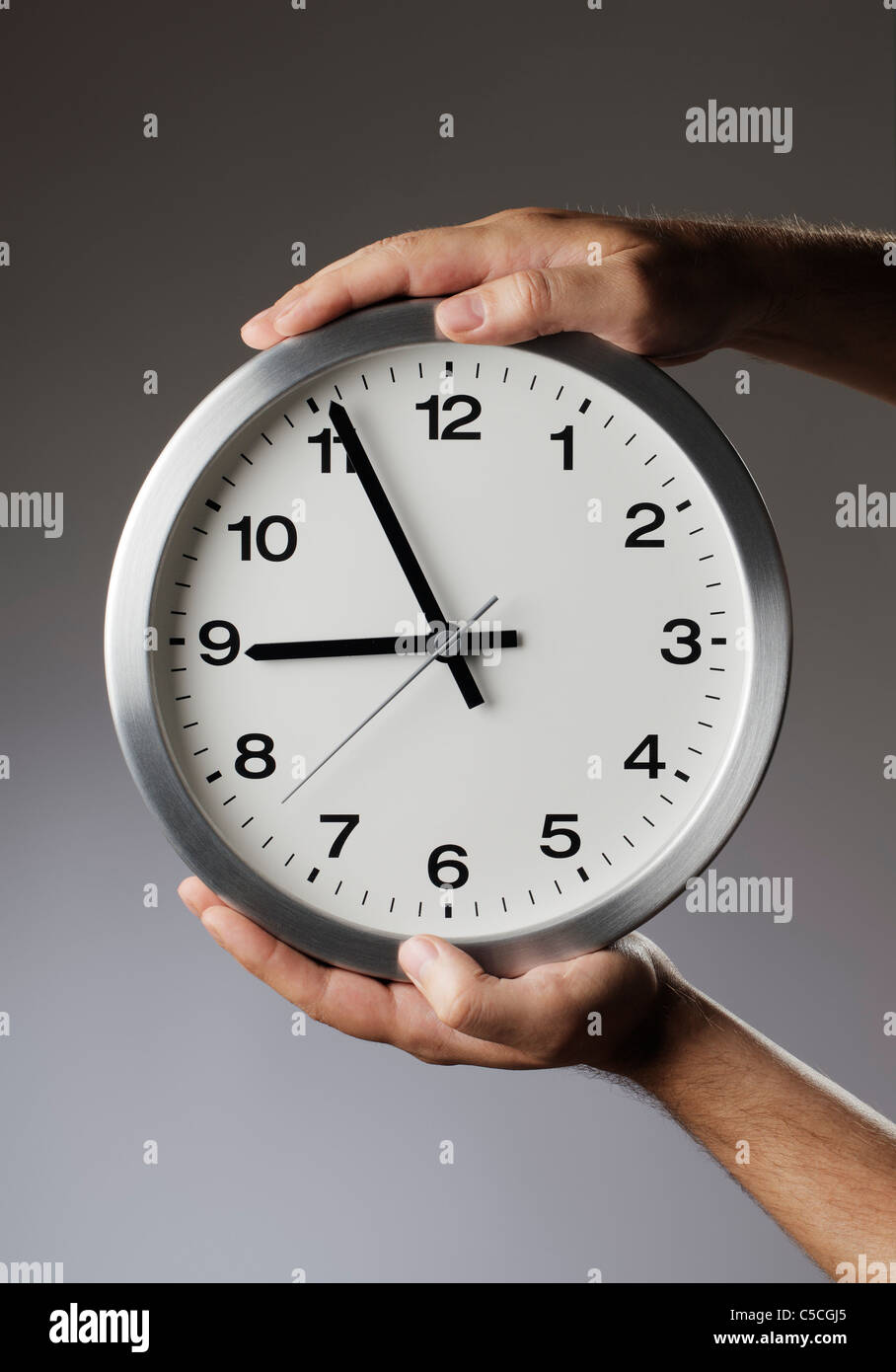 Man holding a clock in his hands Stock Photo - Alamy