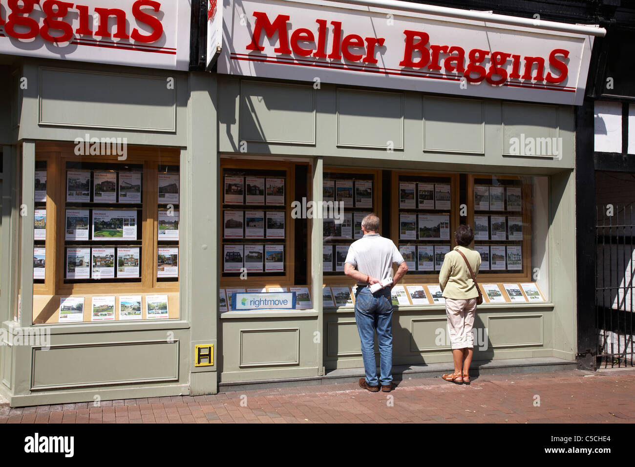 Couple looking in estate agent shop window Stock Photo - Alamy