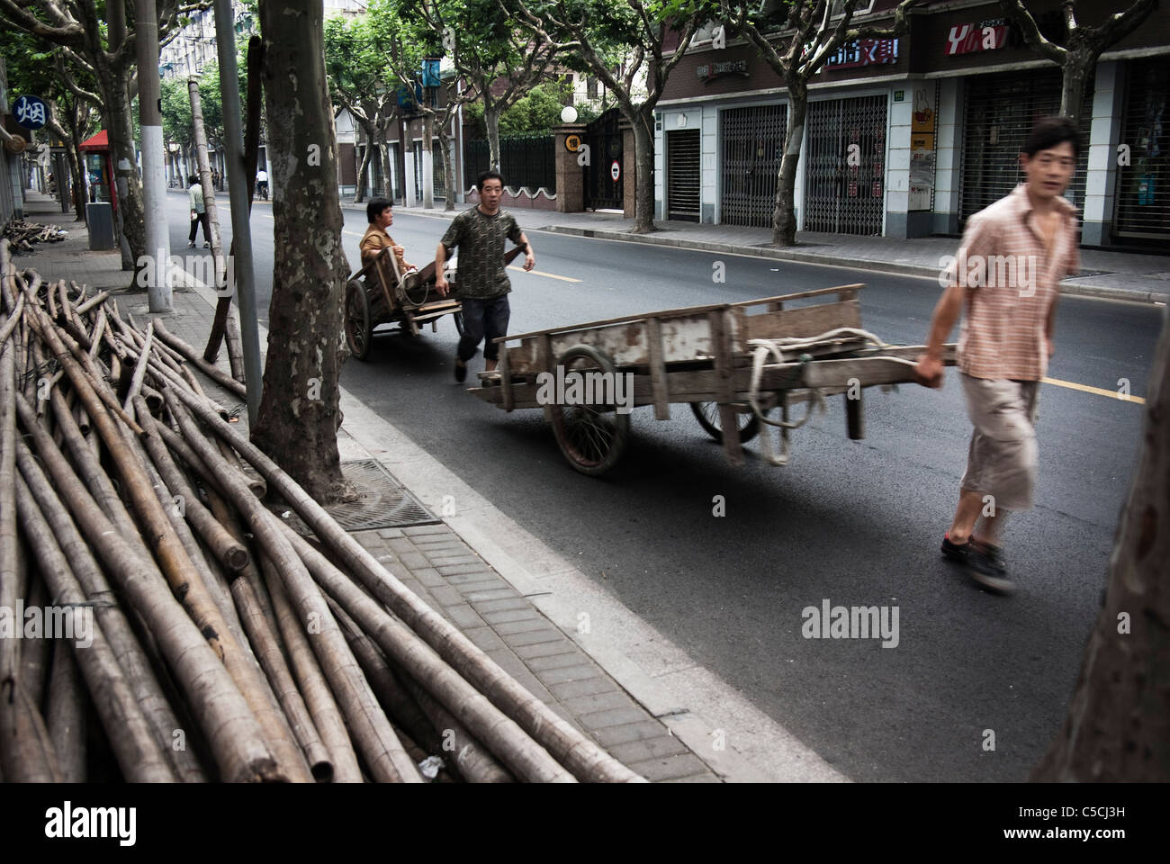 men pulling carts on an empty street,shanghai,china Stock Photo - Alamy