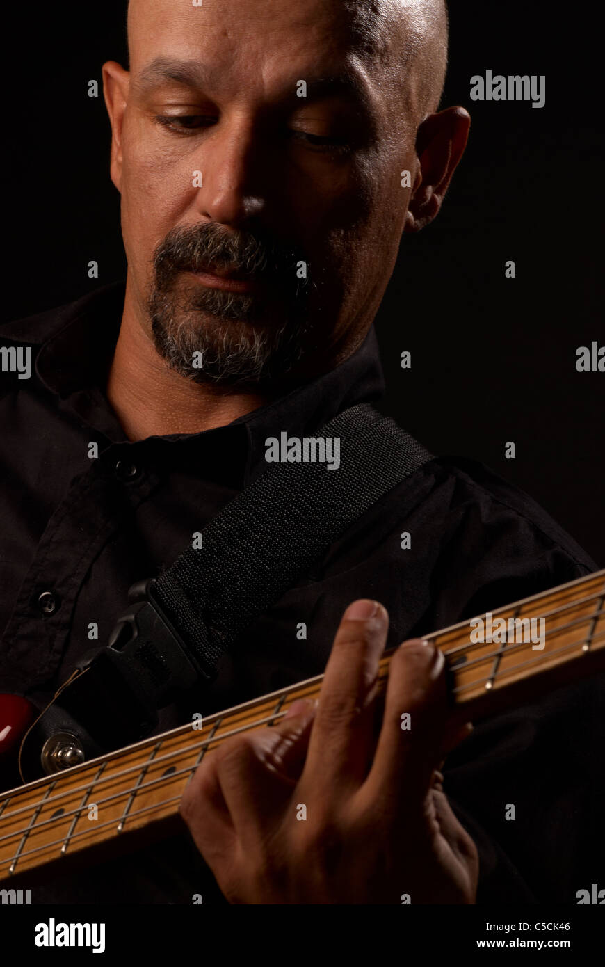 Closeup take of a man playing an electric bass Stock Photo - Alamy