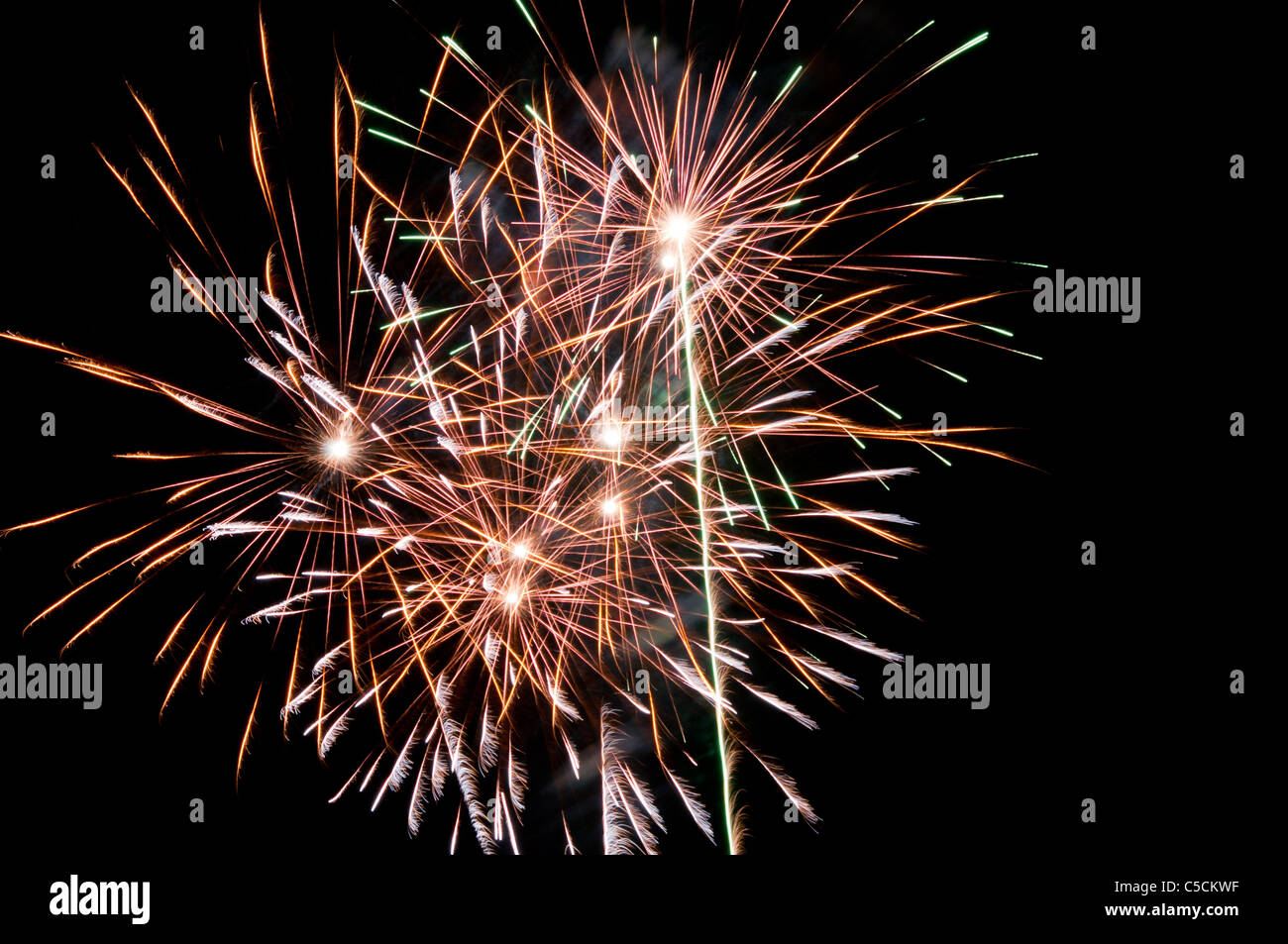 Yellow, white, orange and green fireworks exploding in the night sky. A ...
