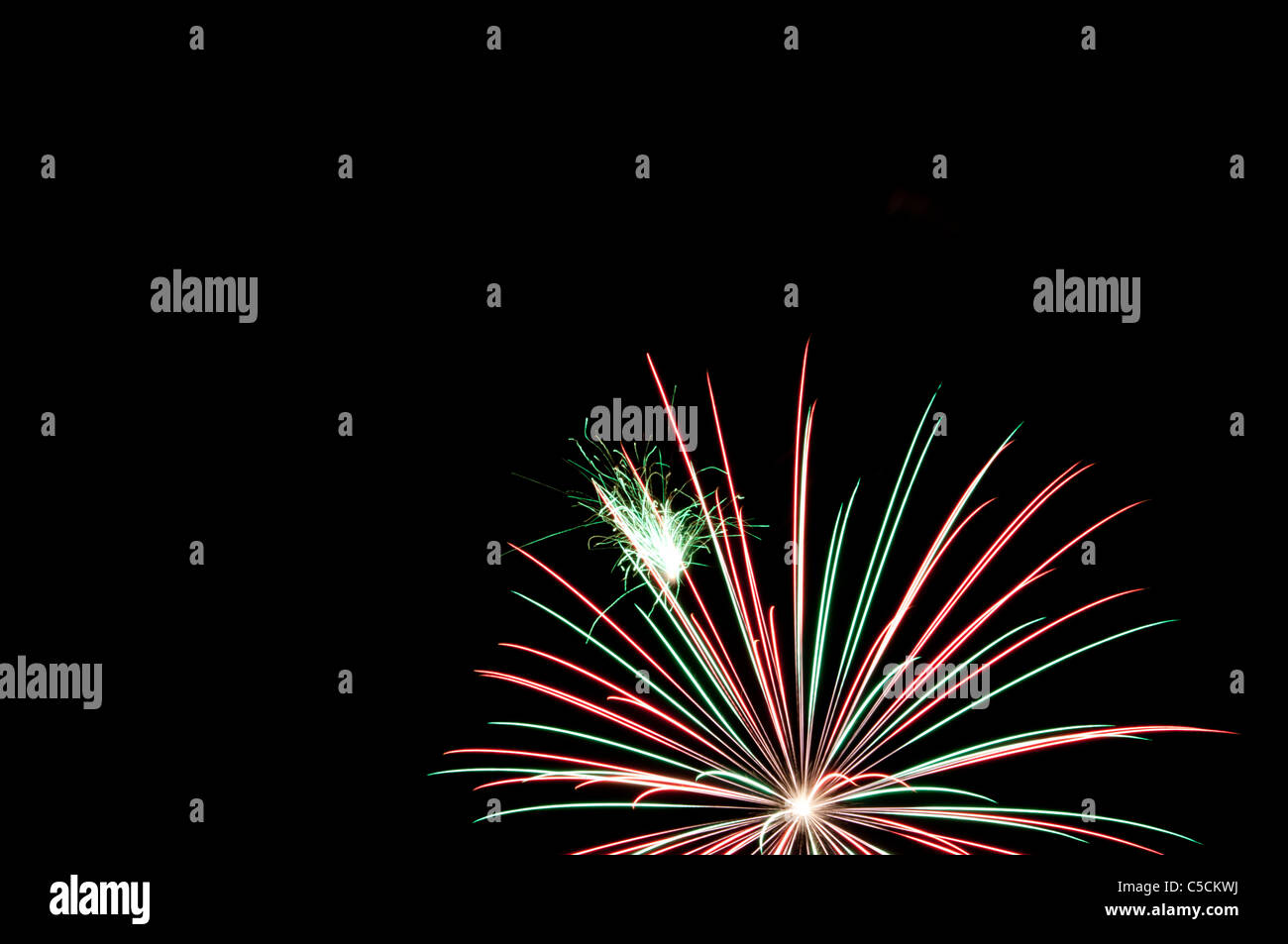 Red and green fireworks exploding in the night sky. A celebration of ...