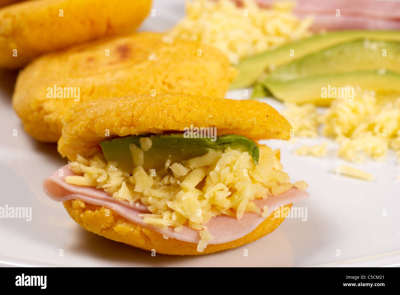 Arrangement of traditional arepas filled with avocado, ham and cheese ...