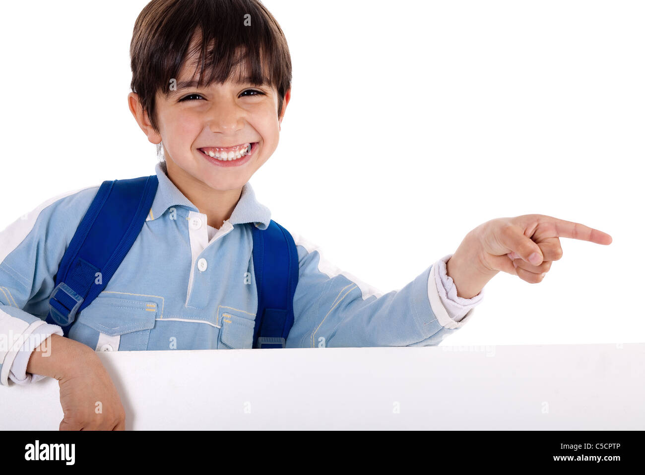 Happy young boy pointing to copyspace on isolated white background ...