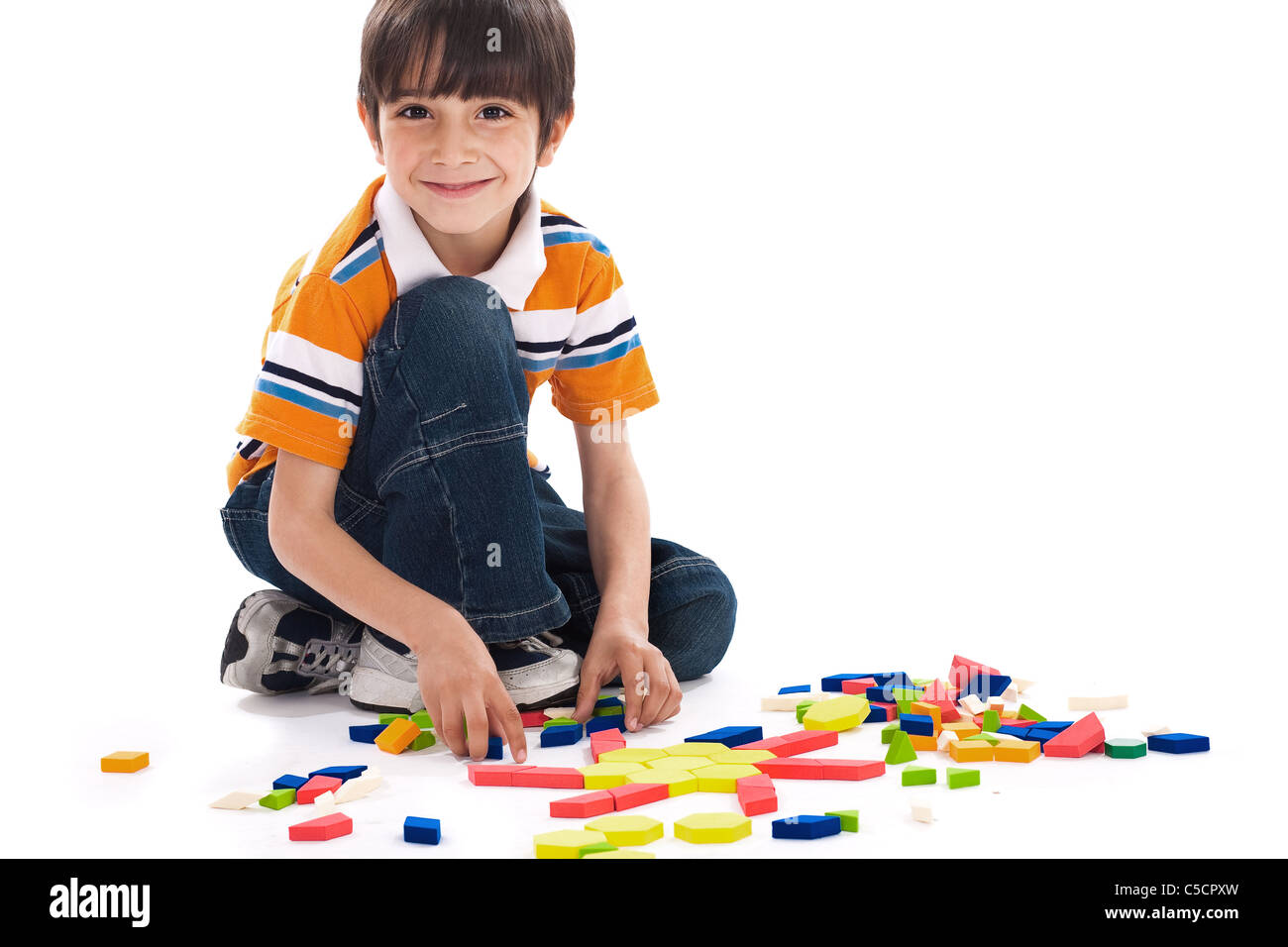 Adorable caucasian boy joining the blocks while playing on white ...