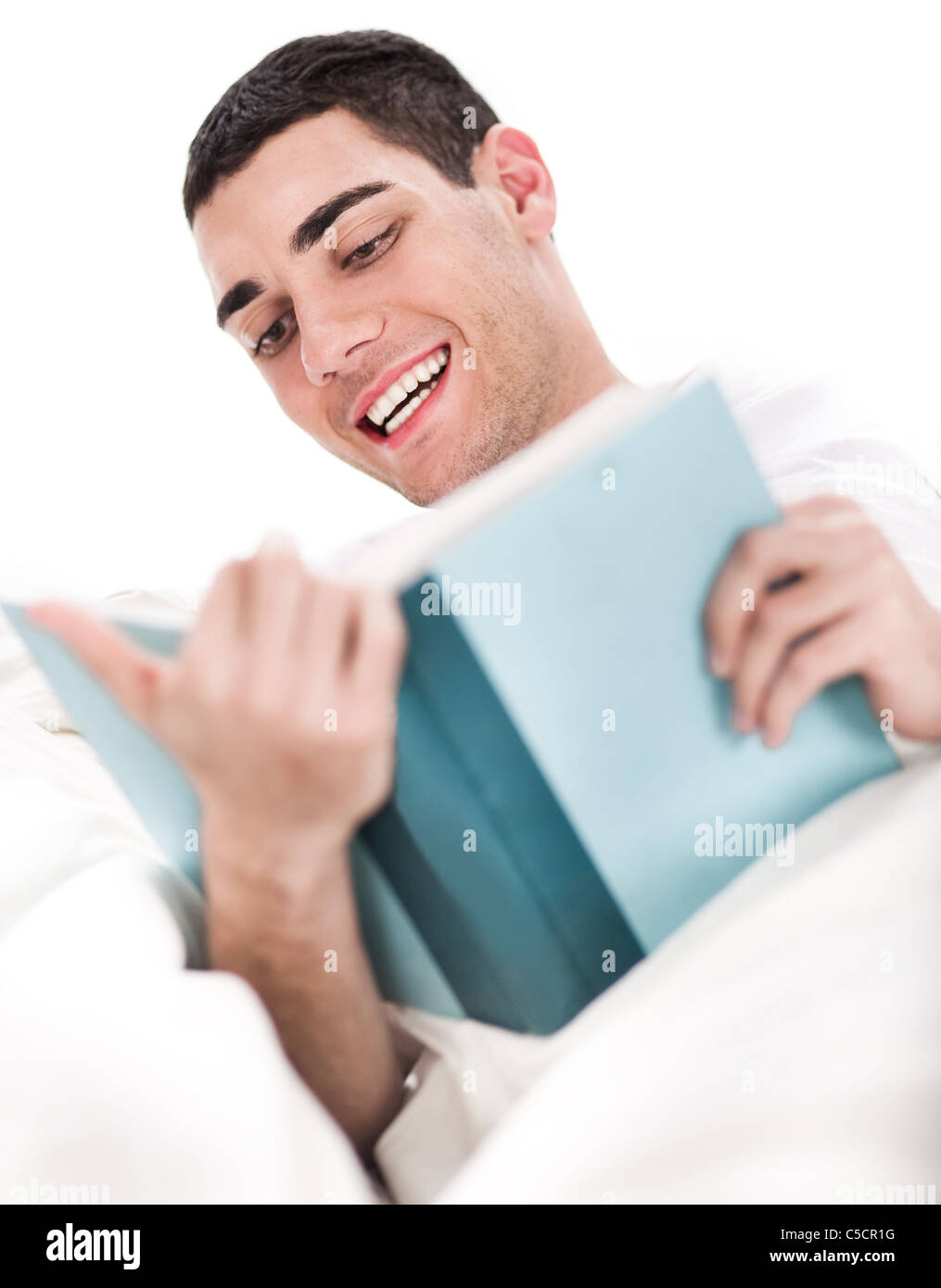 Young man enjoy reading book in bed over white background Stock Photo ...