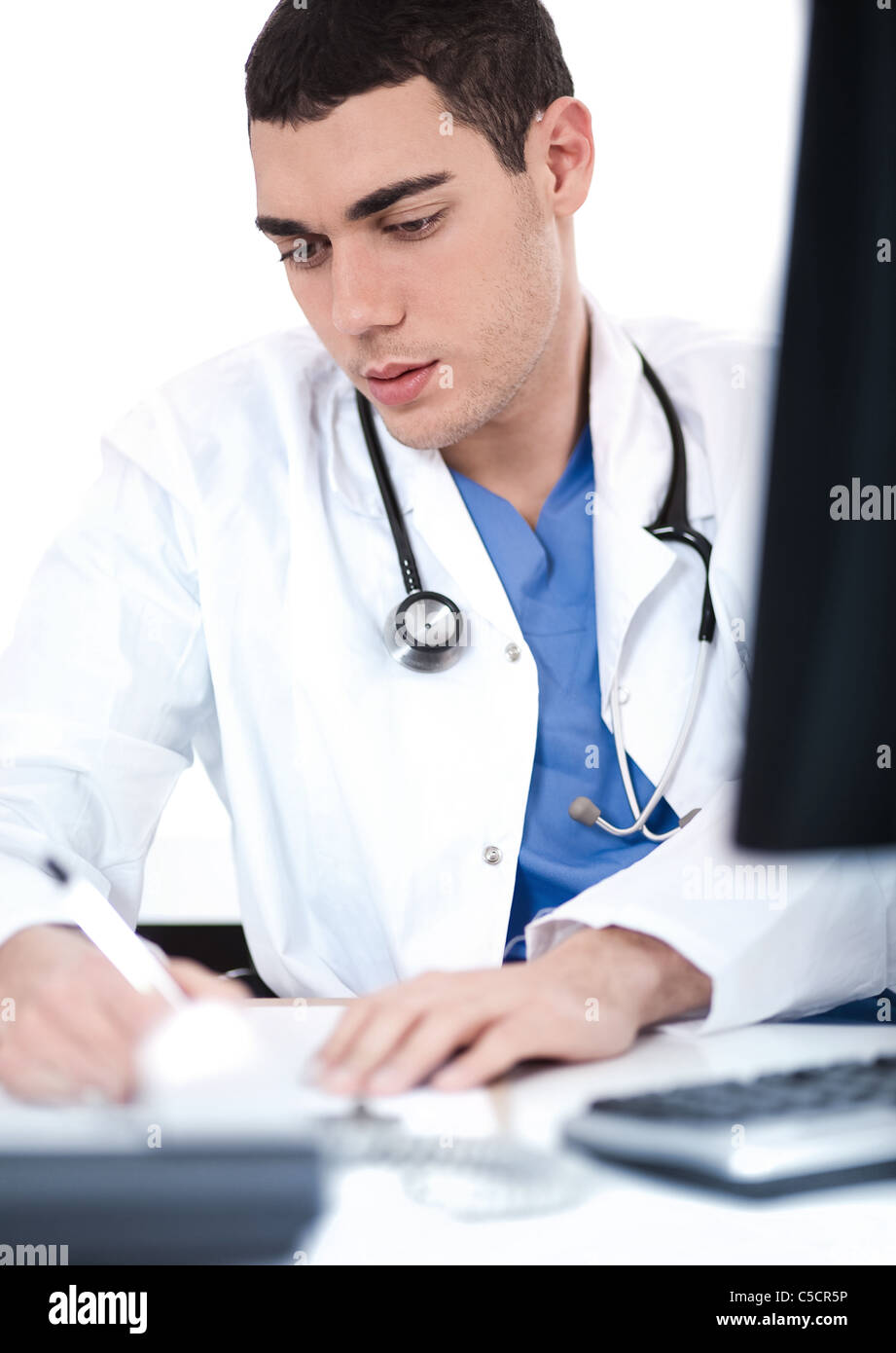 Handsome doctor making notes from the computer at his desk Stock Photo ...