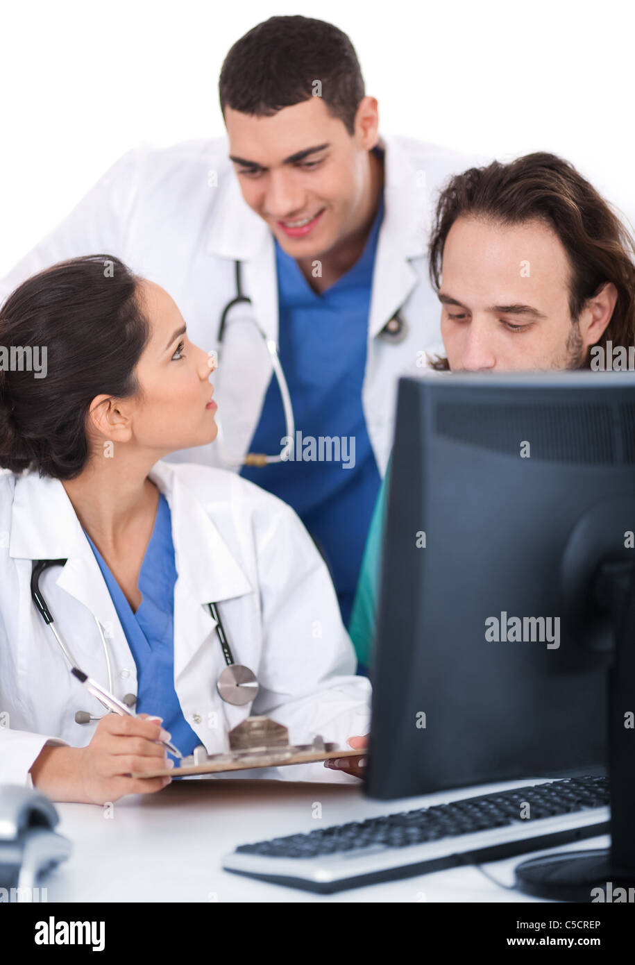 Young doctors team discussing and making notes from computer on ...