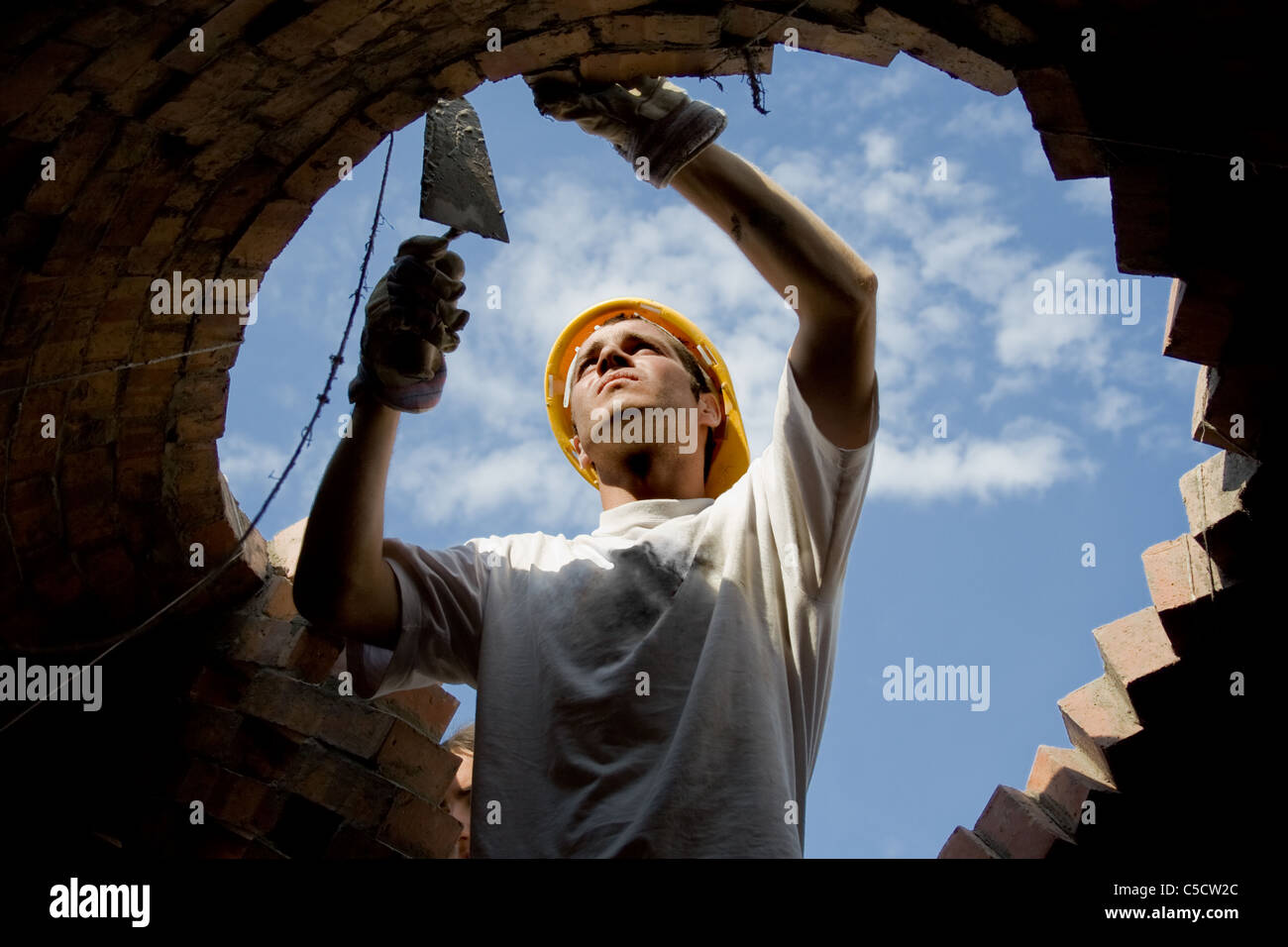 Man at work - an architect building an African structure. under blu sky ...