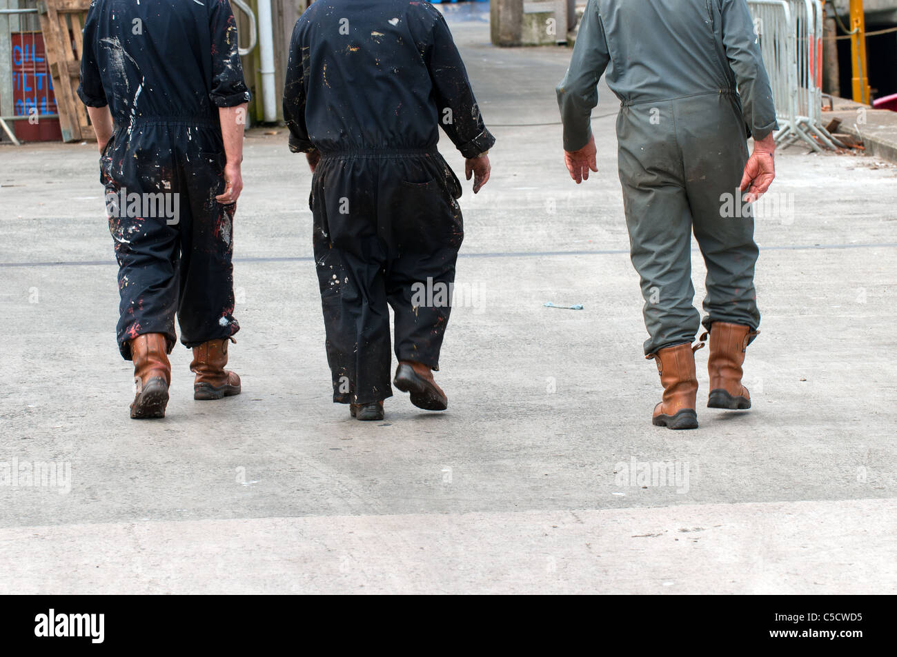 Three workers walking Stock Photo - Alamy