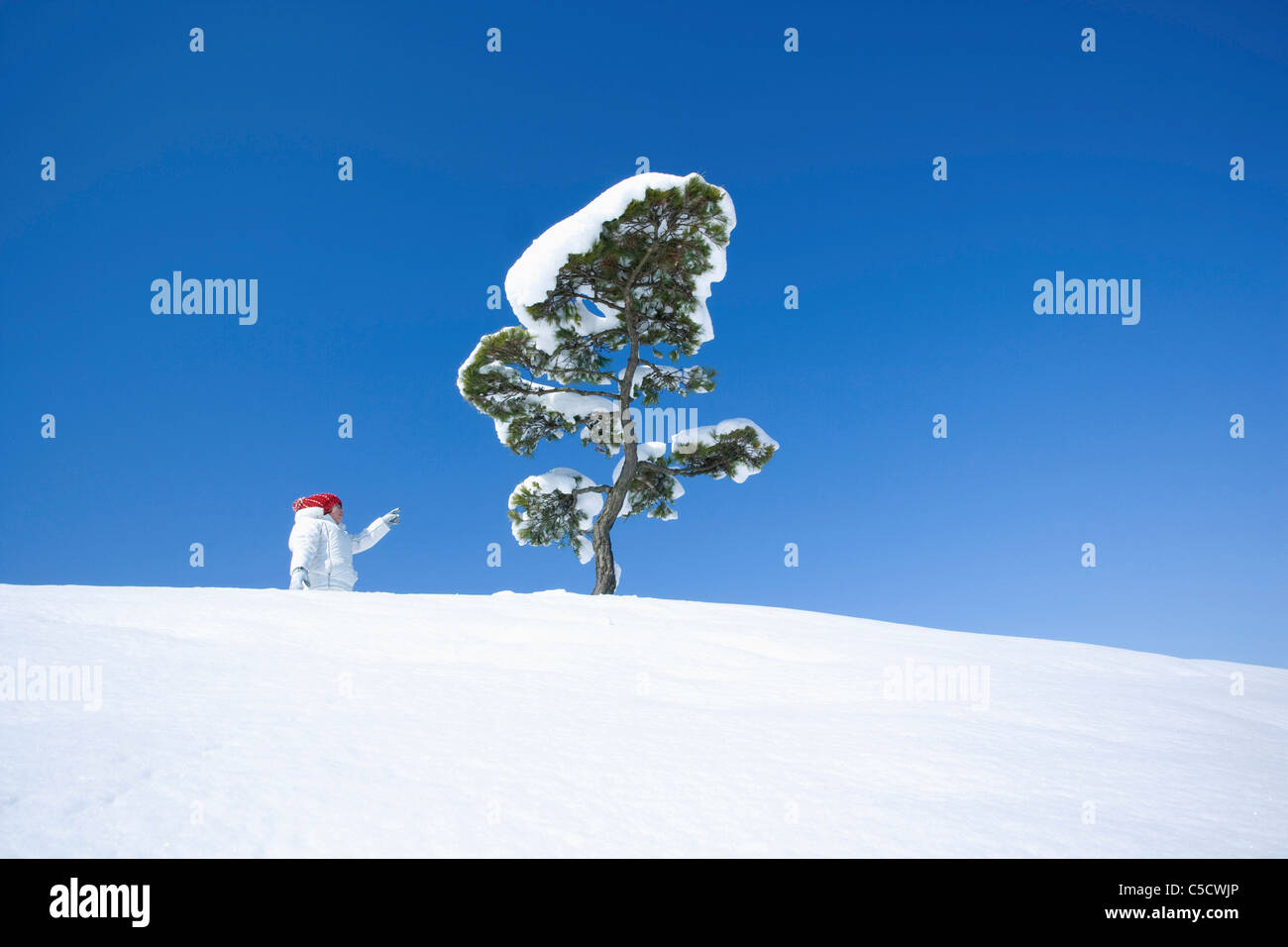 girl stood on the snow field pointing at tree Stock Photo - Alamy