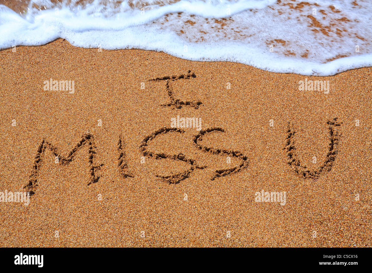 Writing on the sand with water coming to erase it Stock Photo - Alamy