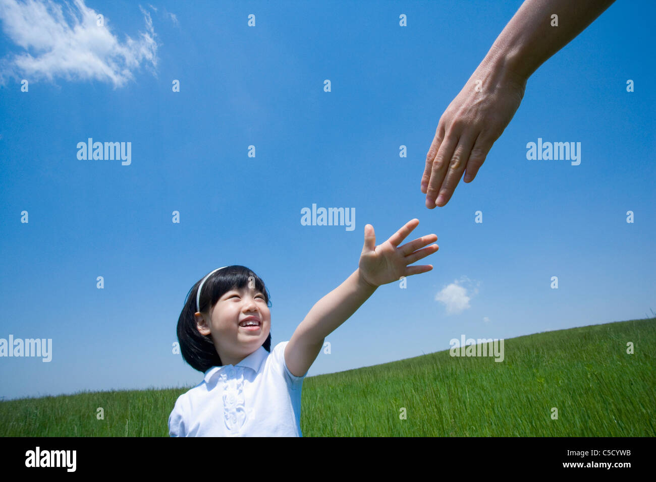 girl outstretched arm to grab other's hand Stock Photo - Alamy