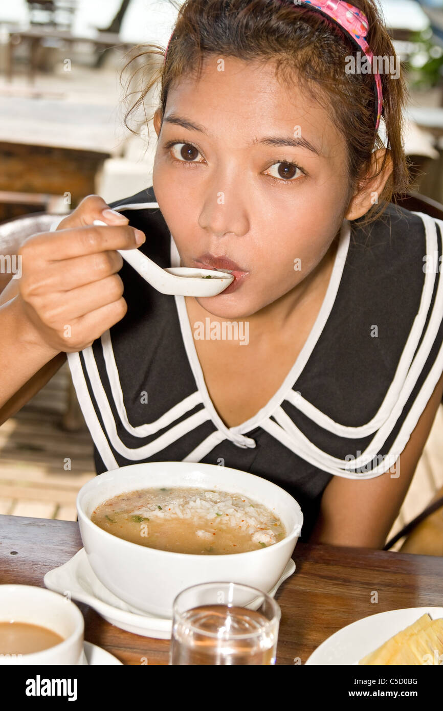 Girl tastes the boiled rice Stock Photo - Alamy